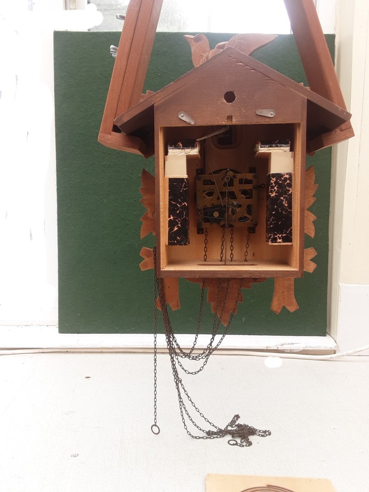 Repairers cuckoo clock stand for final adjustments testing time chimes ...