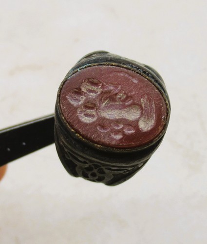 AN ANCIENT ROMAN BRONZE SIGNET RING WITH A RED STONE CRYSTAL INTAGLIO ...