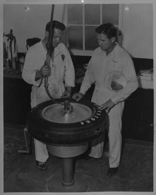 Driver Duane Carter and a Firestone employee air a tire in a ga 1950 ...