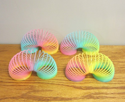 4 NEW MAGIC GLOW IN THE DARK COIL SPRINGS MULTI COLORED 3" PLASTIC COIL ...