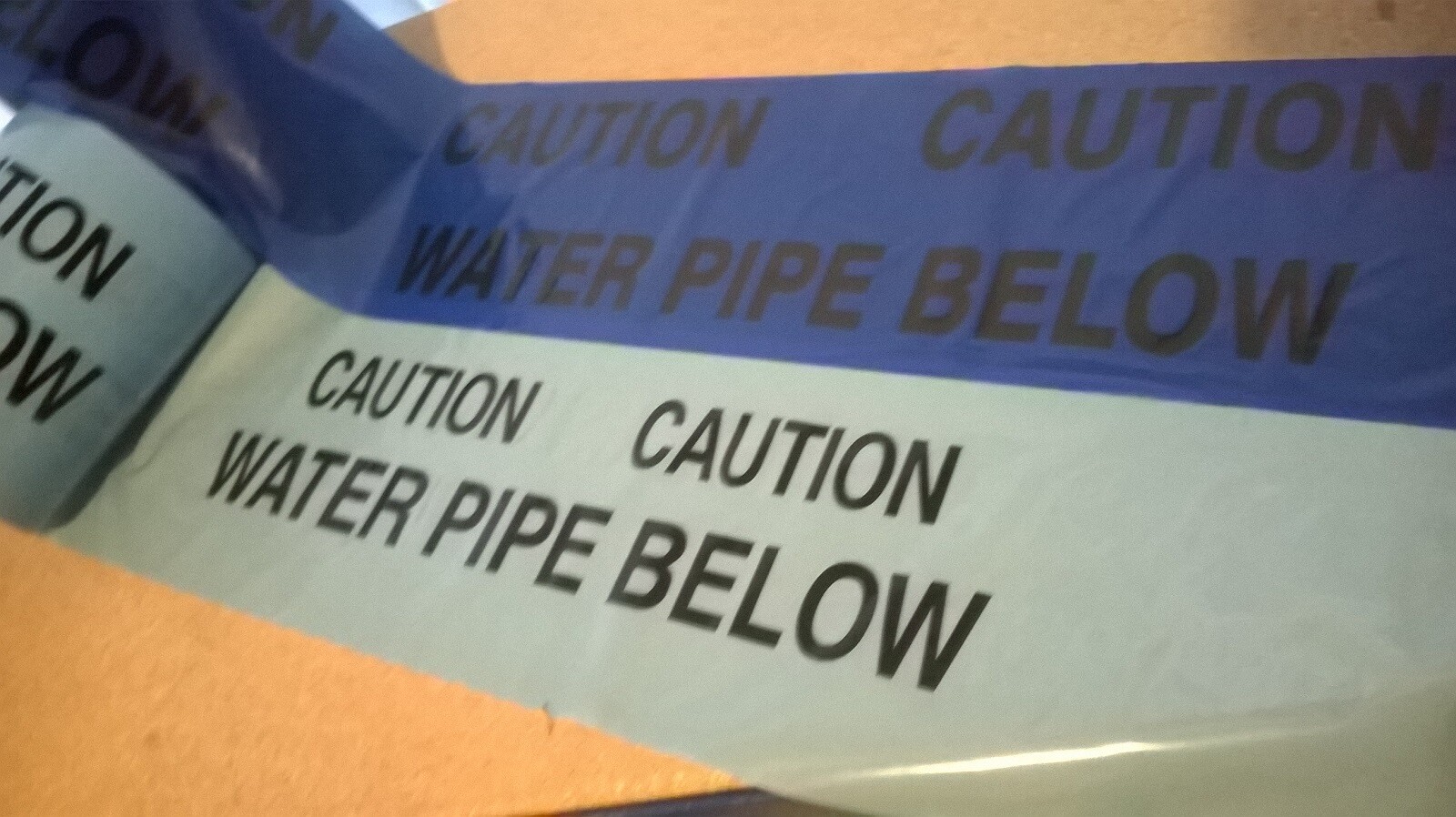 CAUTION WATER PIPE BELOW Underground buried supply warning tape cut ...