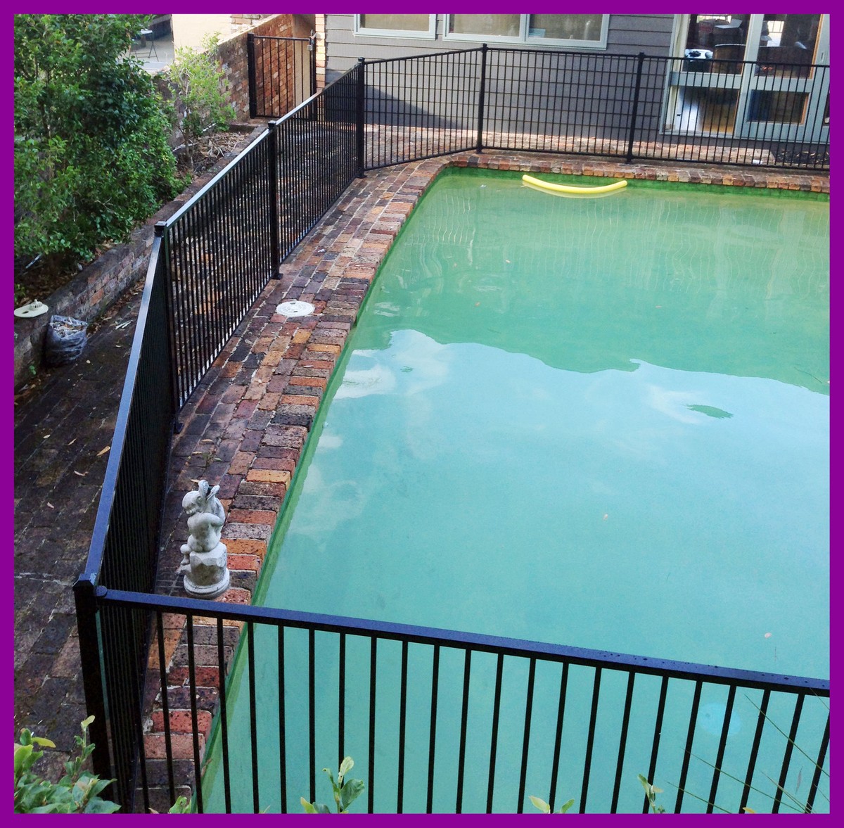 Black Fence And Shrubs Around Pools
