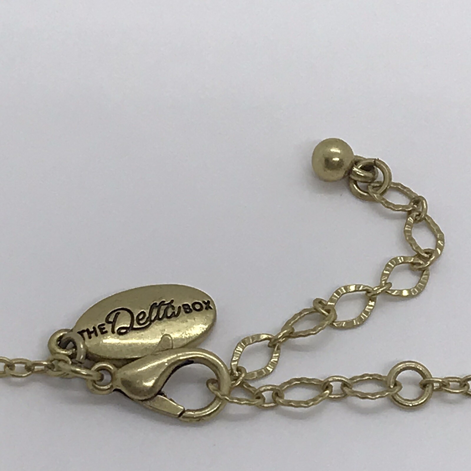 The Delta Box brass tone trunk up Elephant chain neck… - Gem