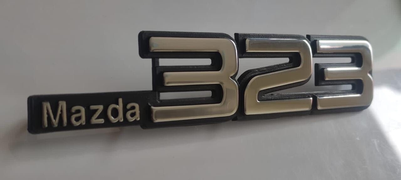 Fits MAZDA 323 EMBLEM ORNAMENT " MAZDA 323 " CHROME Badge Logo Carro ...