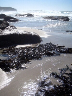 Photo 6x4 Rocks and seaweed on Sennen Beach Carn Towan In the distance ...
