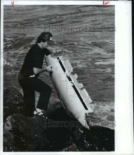 1989 Press Photo Kim Bevers pulls helicopter part from Gulf of Mexico ...