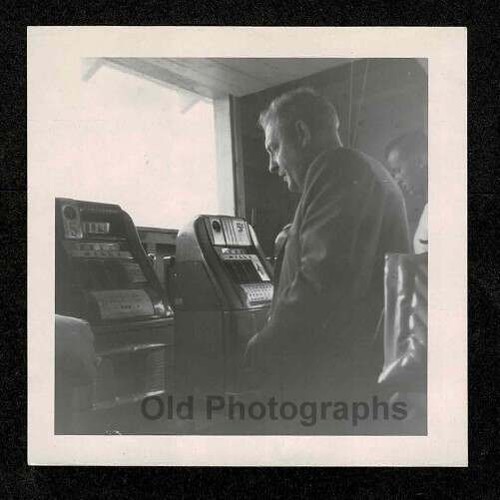 MAN PLAYING OLD/VINTAGE SLOT MACHINE SUNLIT WINDOW OLD/VINTAGE PHOTO ...