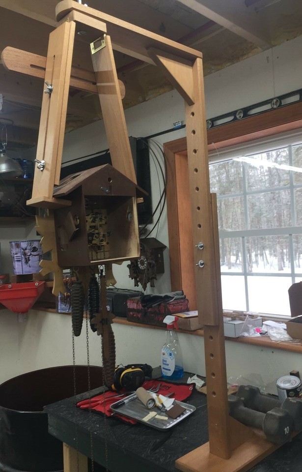 Repairers cuckoo clock stand for final adjustments testing time chimes ...