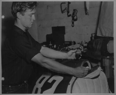 Duane Carter pours a liquid into the gas tank of the #82 in a g 1950 ...