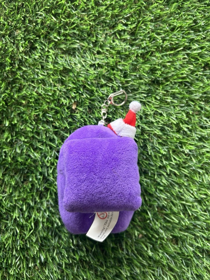 Among Us plush toy, specifically a purple crewmate wearing a Santa hat ...