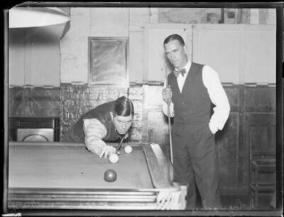 Clark McConachy taking a shot in a game of billiards against Walte ...