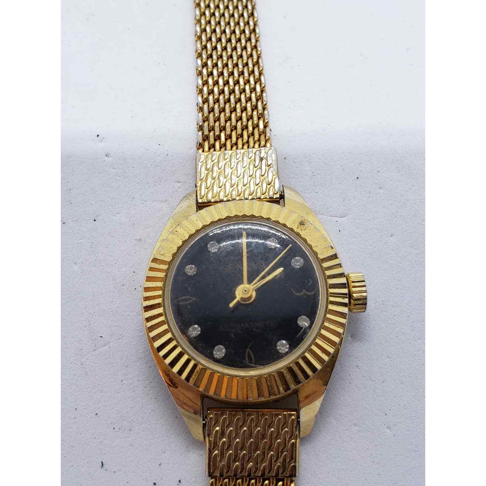 Geneva women's watch. Black face. Large decorative gold bevel. Sold as ...
