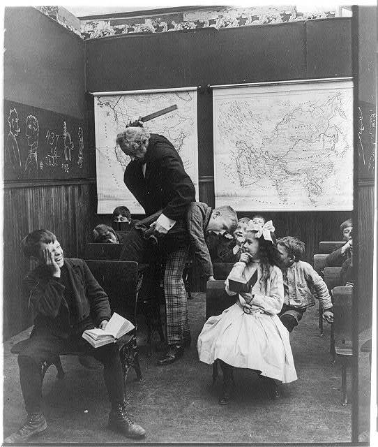 Teacher spanking small boy with ruler in classroom, posed scene Old ...