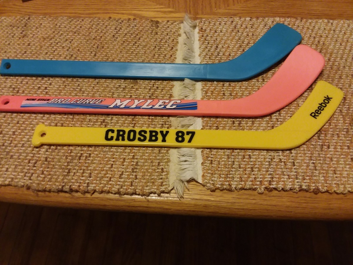 Mini Hockey Stick Wall Mount Poster A Small, Silver Robot With A Gold