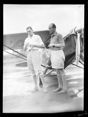 Aviators Bernard Rubin and Ken Waller standing next to a plane, Ma ...