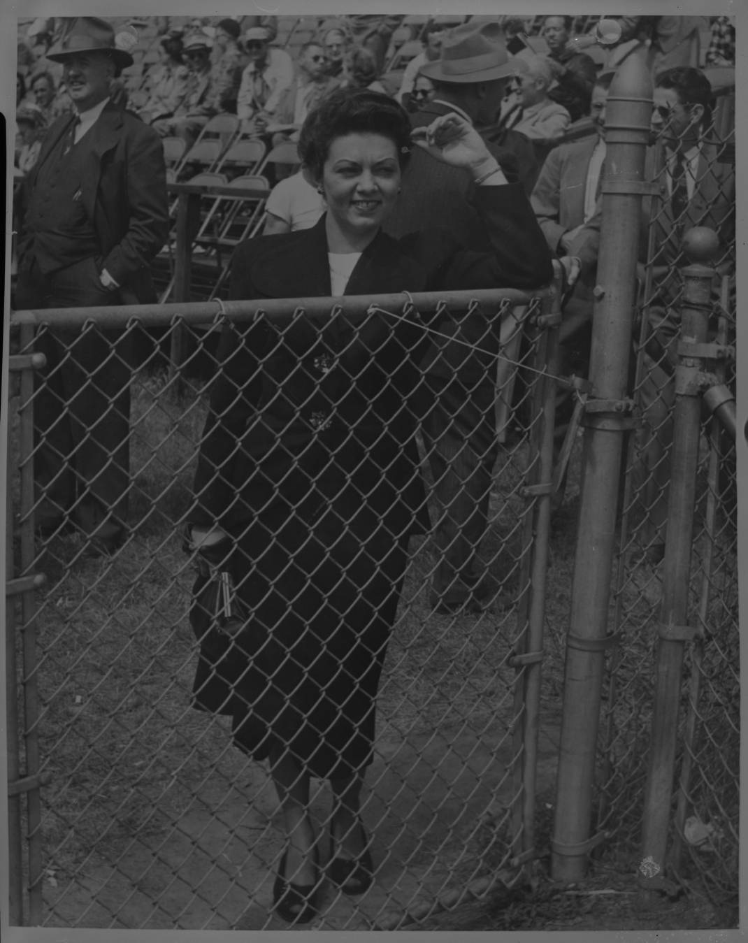 Driver George Fonder's wife leans against the fence beside the 1949 ...