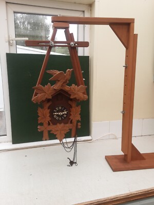 Repairers cuckoo clock stand for final adjustments testing time chimes ...