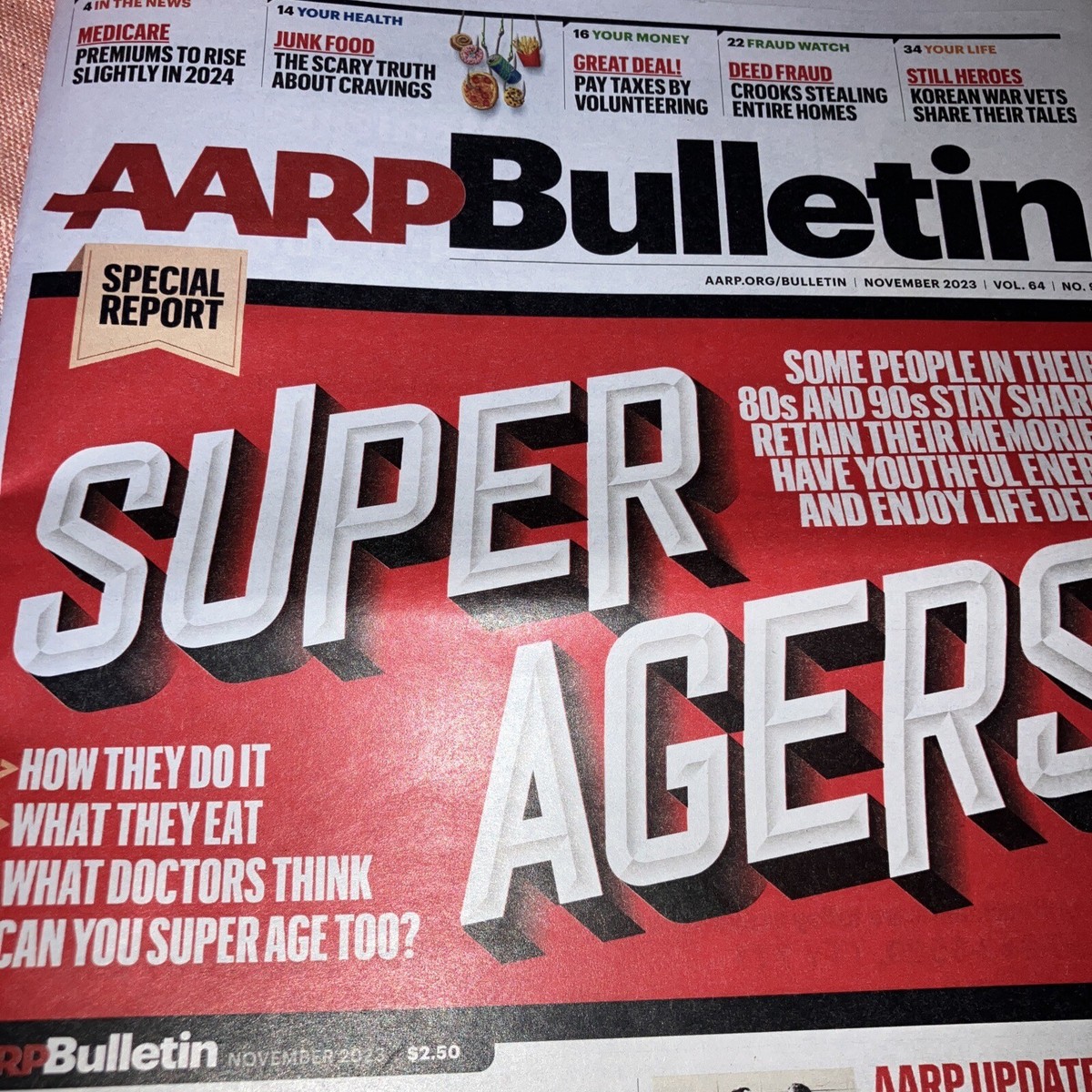 Aarp Bulletin Logo A Woman Removes Her Mail, Including A Copy Of The