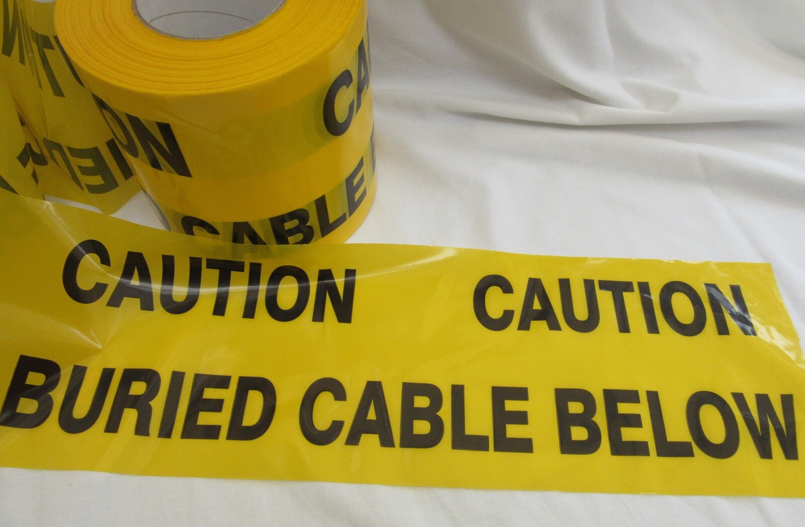 CAUTION BURIED CABLE BELOW Underground buried cable warning tape cut ...
