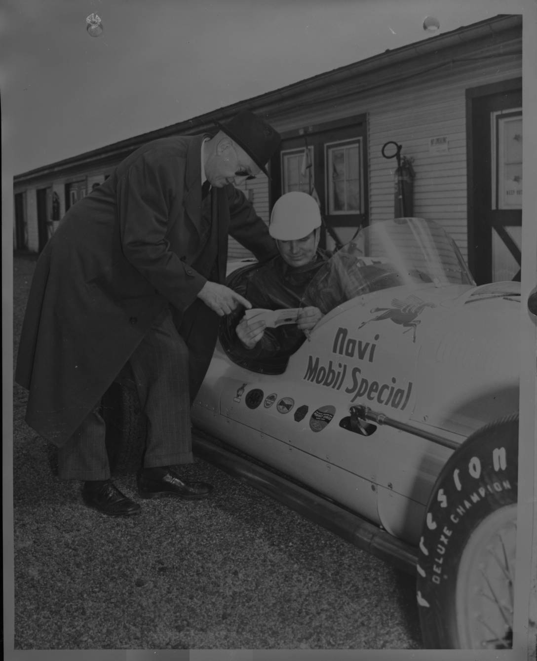 Duke Nalon sits in the Novi Mobil Special as a man shows him a 1949 ...