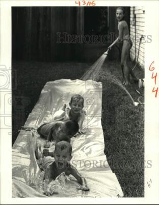 1988 Press Photo Sarah Barkman sprays her brothers to keep cool in ...