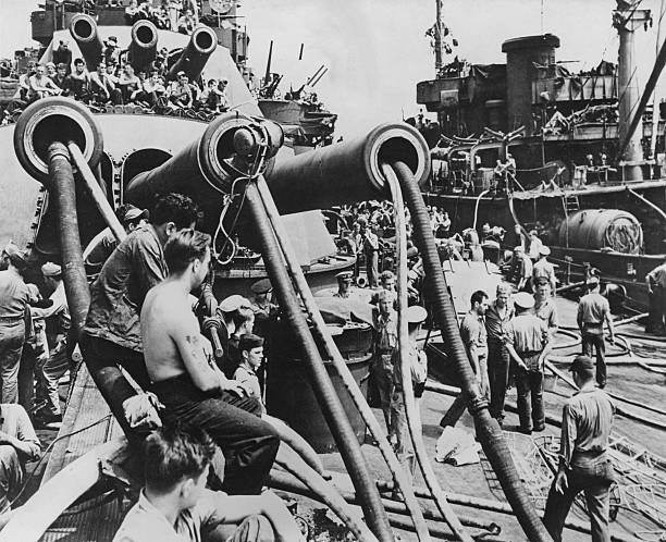 Sailors attend water pumps that have been placed down barrels from- Old ...