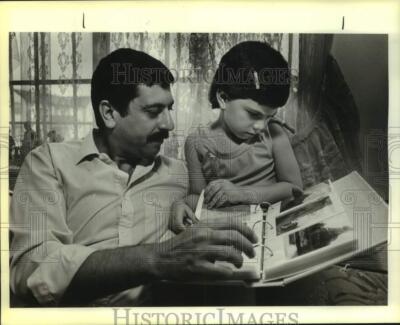 1985 Press Photo Hemmat Youssef looking at pictures with daughter Eman ...