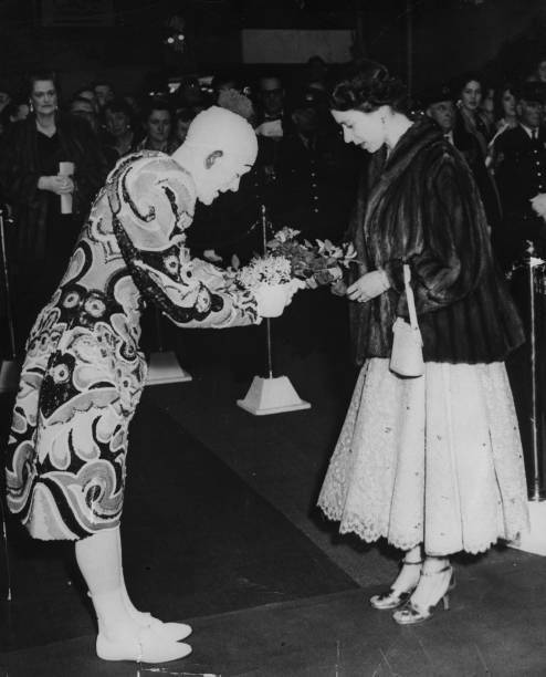 Queen Elizabeth II receives a bouquet Huxter clown as she arri- 1955 ...