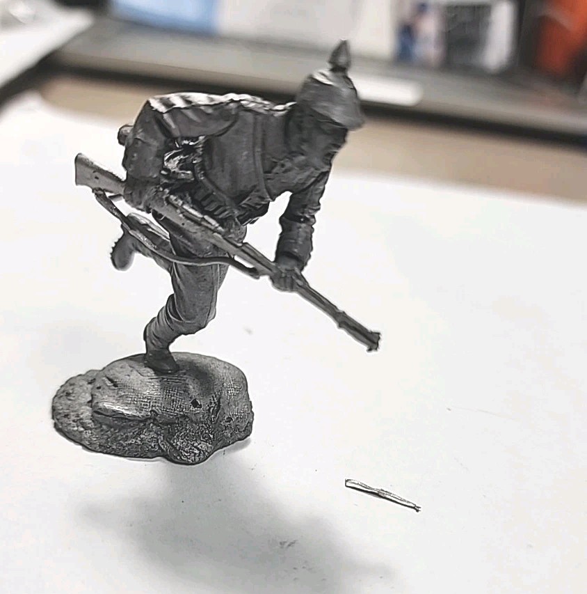 Tin metal miniature figurine of а German infantryman goes on an assault ...