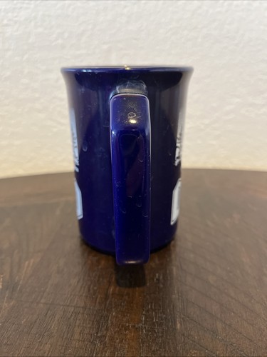 Dark blue coffee mug with a white mountain range graphic and the text ...