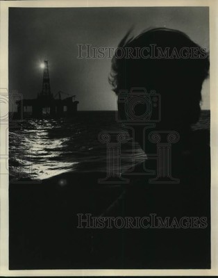 Press Photo Tenneco Oil Company worker's silhouette in offshore oil ...
