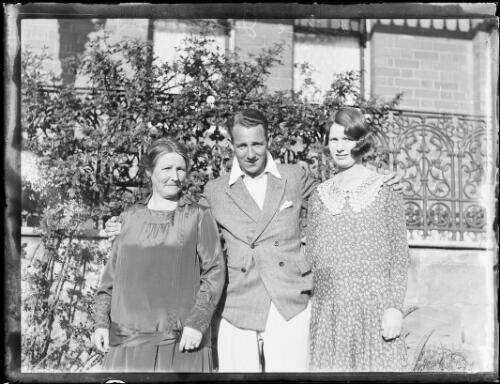 Cricketer Archie Jackson between two women standing in front of a - Old ...