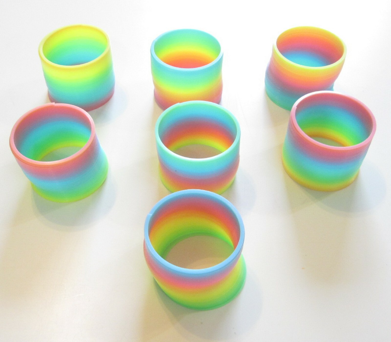 7 NEW MAGIC GLOW IN THE DARK COIL SPRINGS MULTI COLORED 3" PLASTIC COIL ...