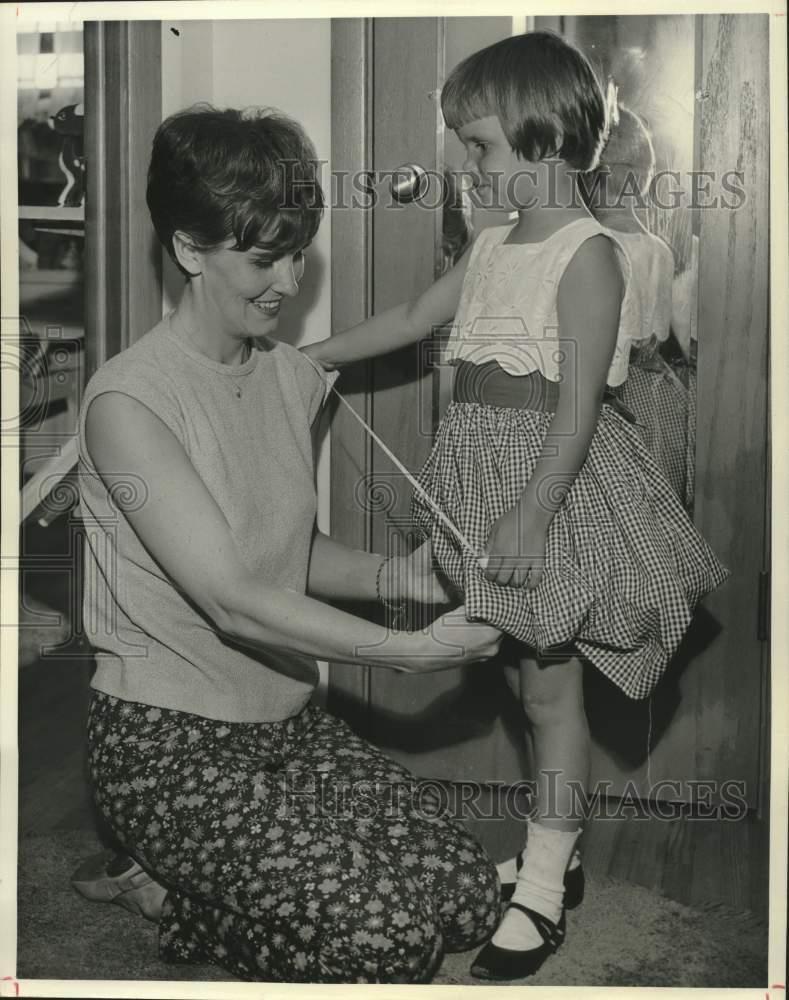 1966 Press Photo Eleanor Thatcher hems up skirt for daughter at home ...