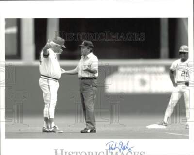 Press Photo Manager Dutch Rennert discusses distance with an umpire ...