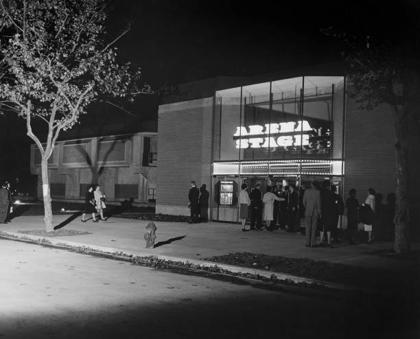 Theatregoers outside Arena Stage theater an illuminated sign above e ...