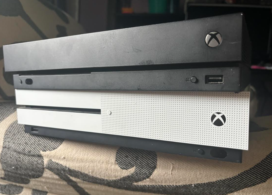 Microsoft Xbox One X (black), Microsoft Xbox One S (white) with power ...