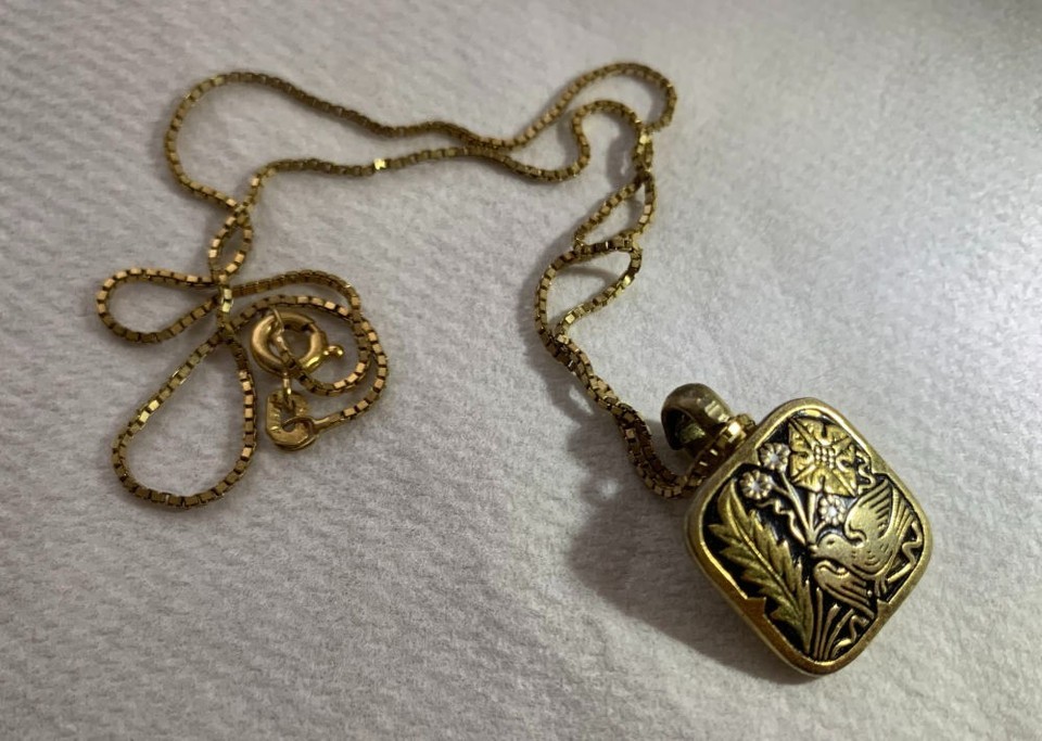 Small gold/silver pendant on gold-coloured chain, made from cufflink ...